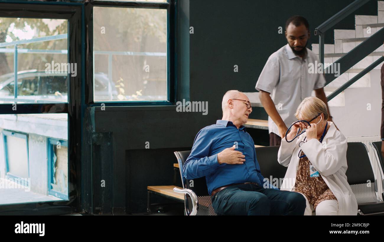 African american people helping elderly man with heart problems to sit ...