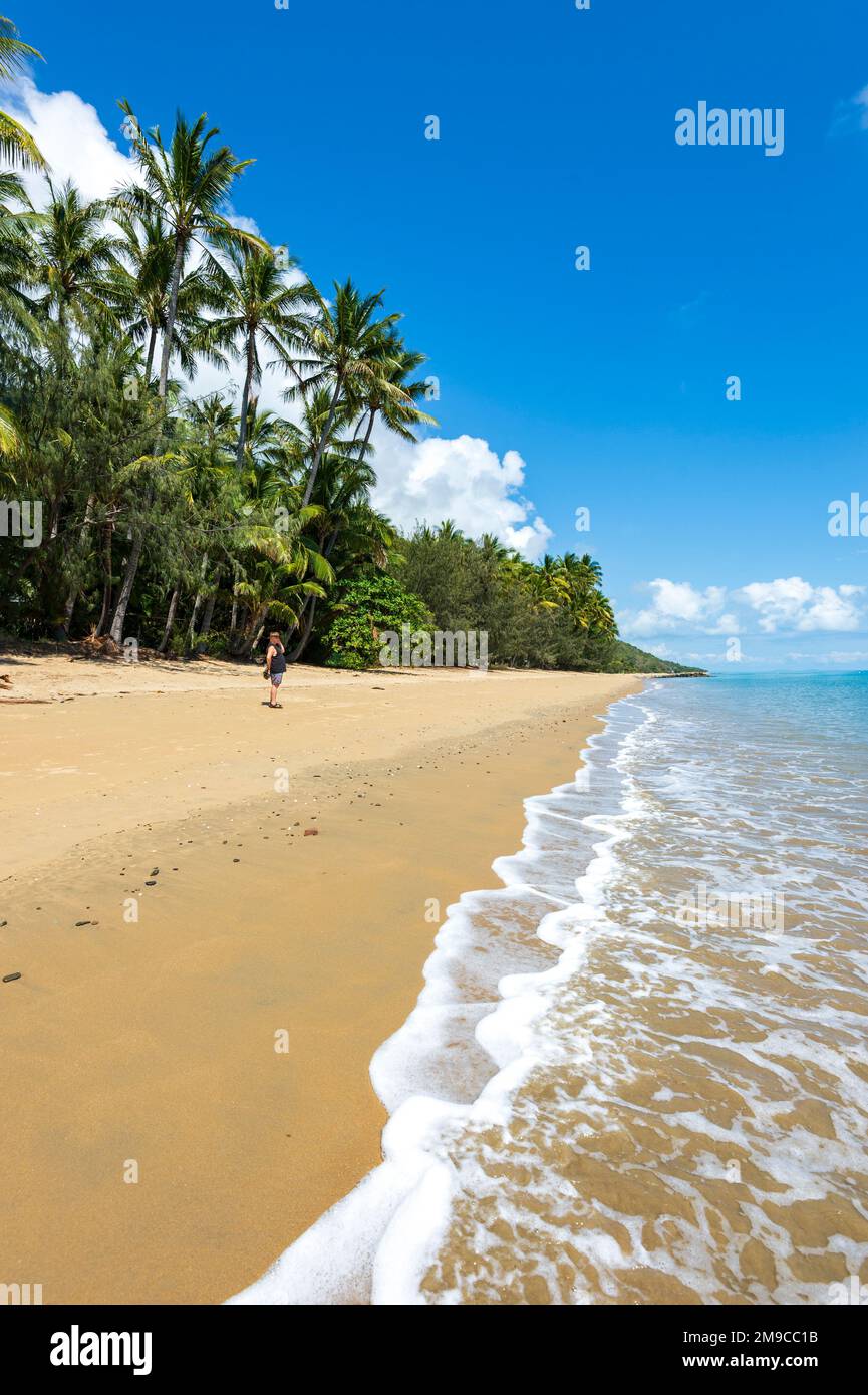 Vertical view of a man walking along the popular tropical sandy beach ... Vertical view of a man walking along the popular tropical sandy beach ...