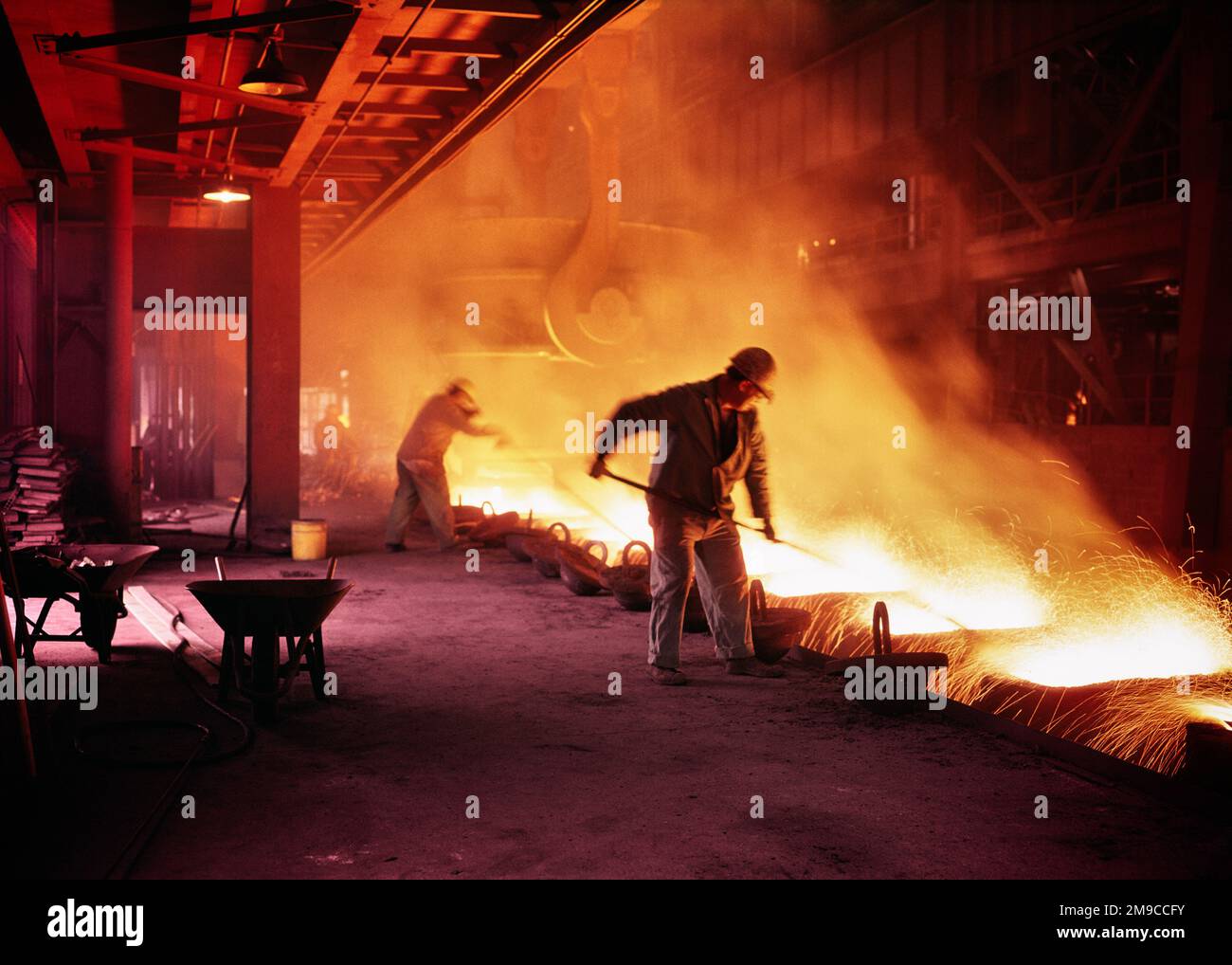 1960s 1970s ANONYMOUS MEN WORKING IN STEEL COMPANY RAKING MOLTEN HOT ...