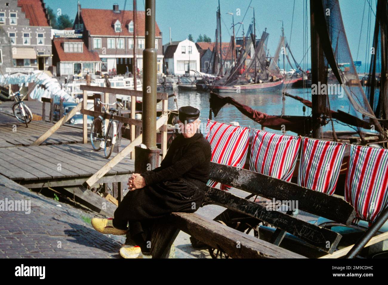 1970s SENIOR MAN SITTING ON WATERFRONT BENCH VOLLENDAM THE NETHERLANDS ...