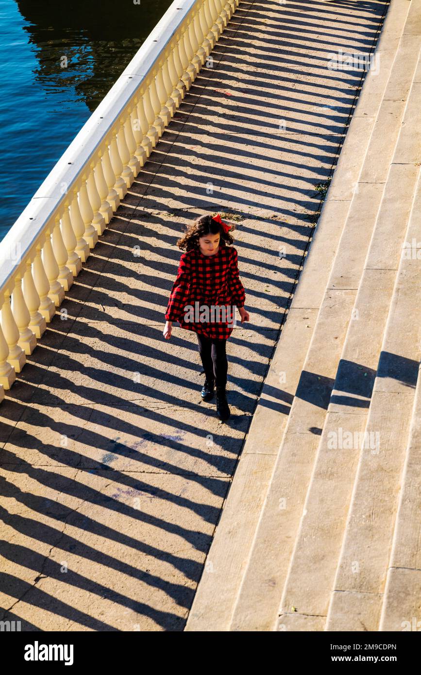 Young girl skipping happily along sunlit stone path; Fairmount Water ...