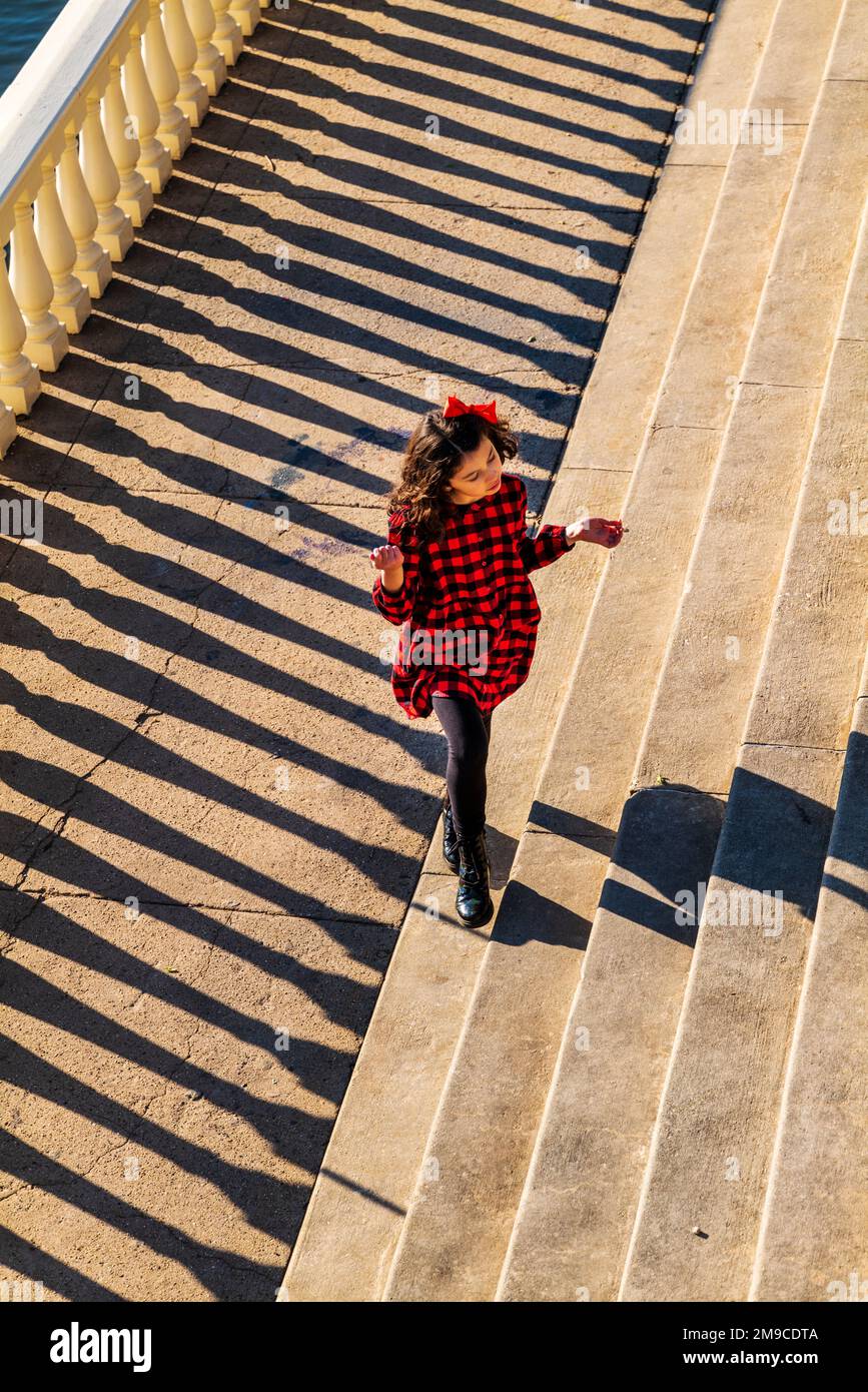 Young girl skipping happily along sunlit stone path; Fairmount Water ...