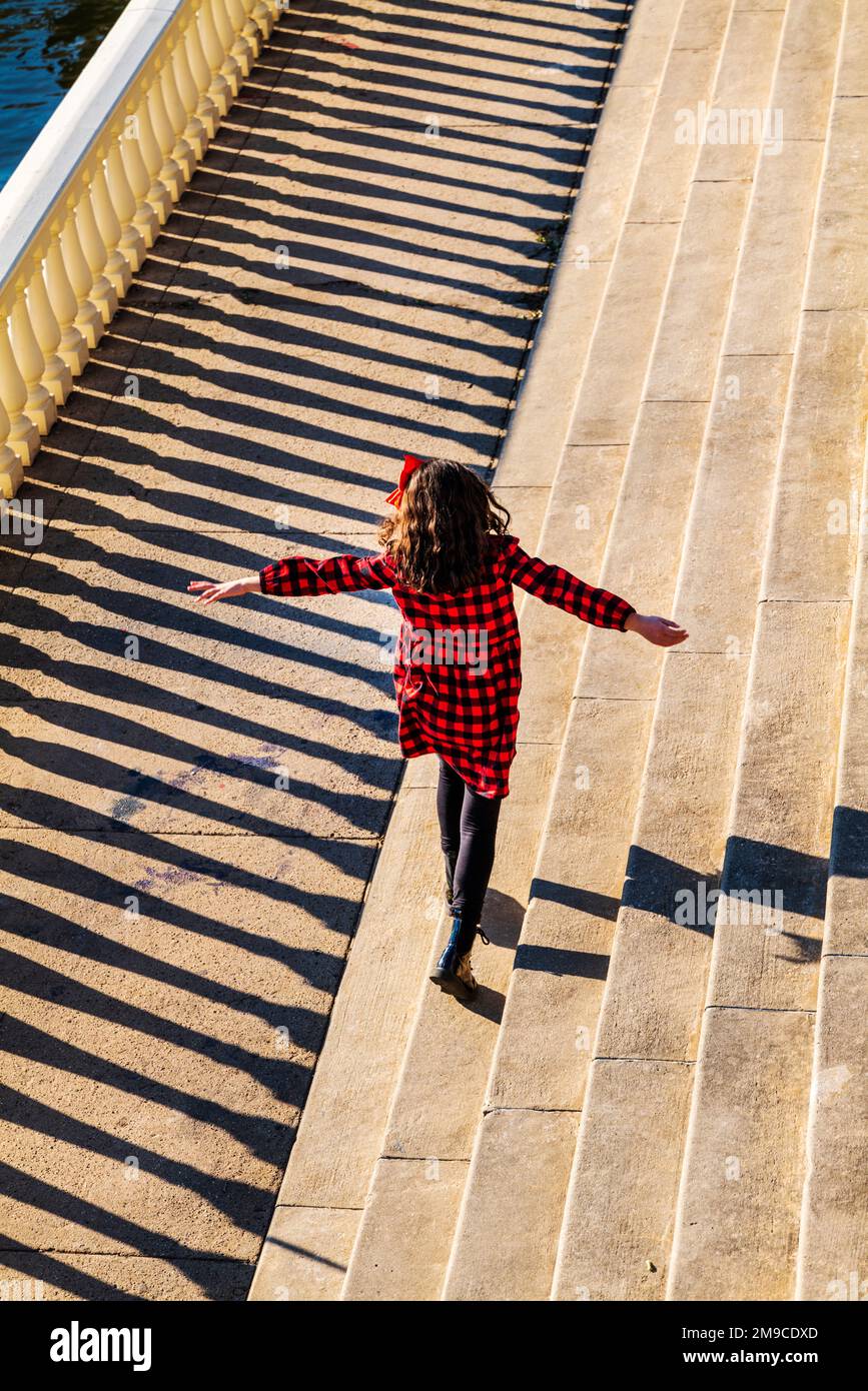 Young girl skipping happily along sunlit stone path; Fairmount Water ...