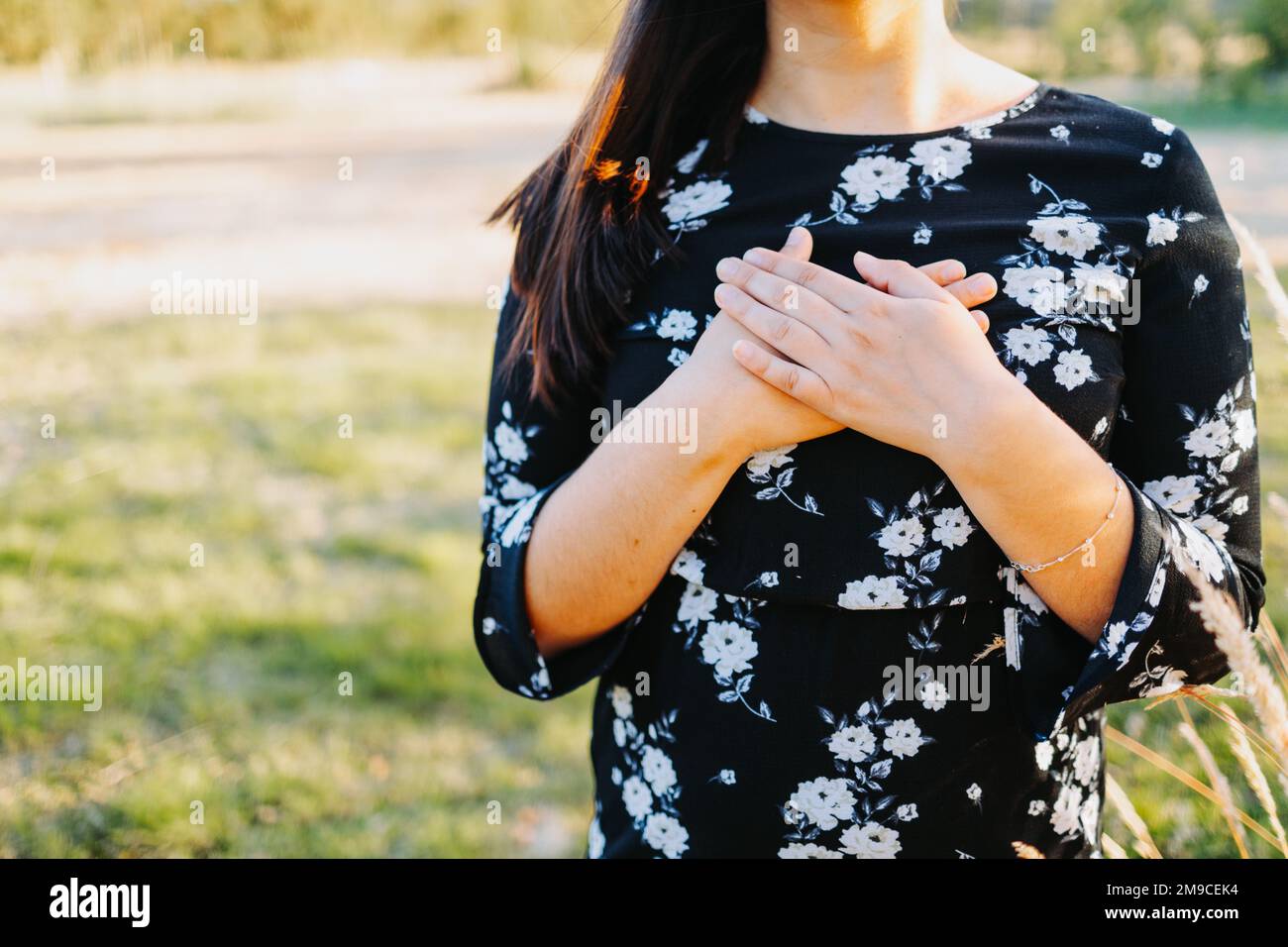 Unrecognizable woman putting hands on her heart in gratitude for God's ...