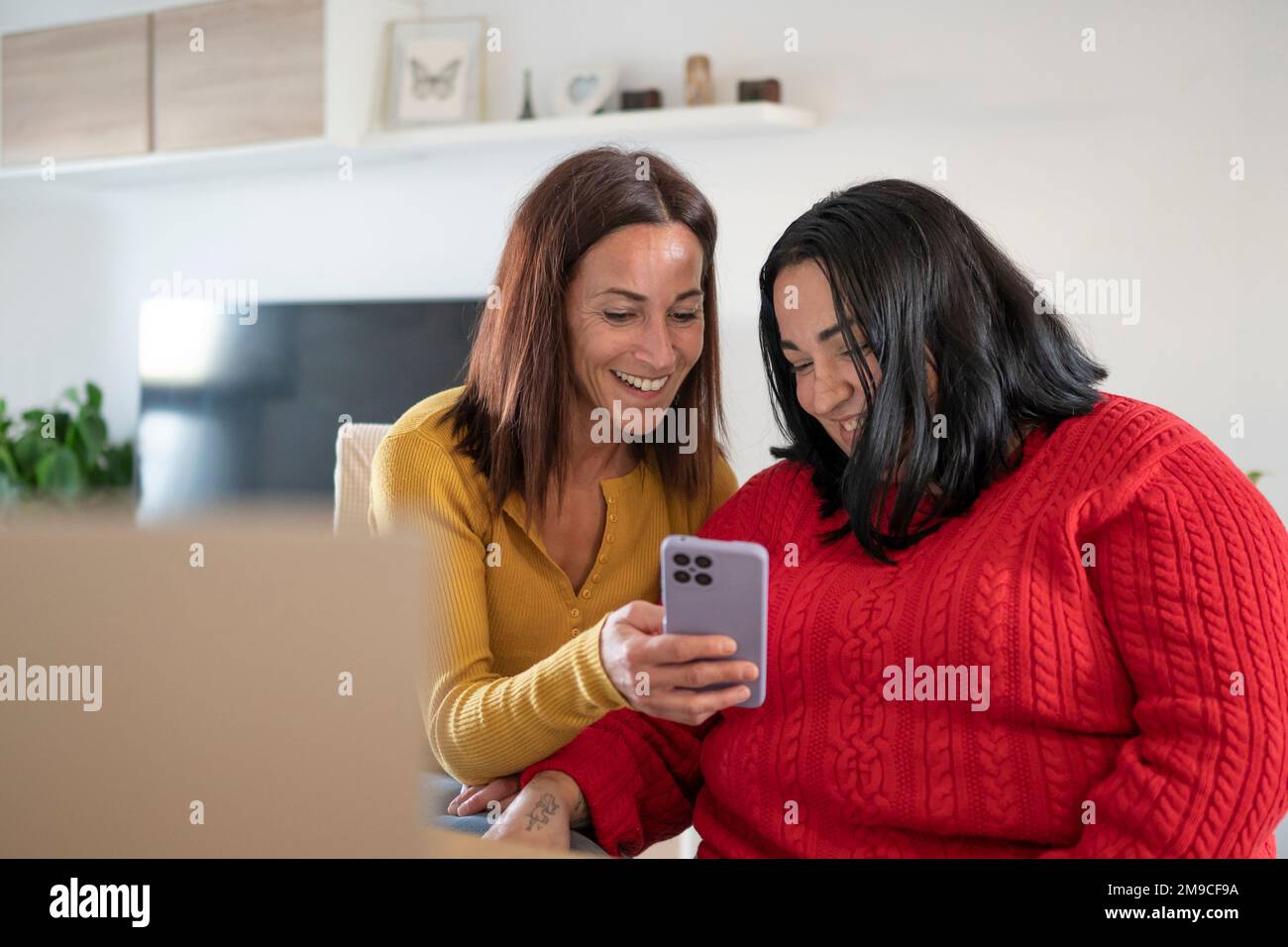 Two different friends looking at something funny on the phone Stock ...