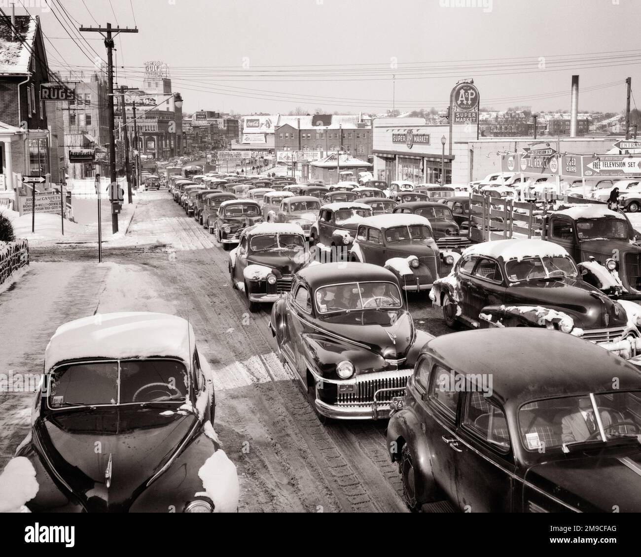 1950s SUBURBAN RUSH HOUR TRAFFIC JAM CARS SLOWED BY ICY SNOWY WINTER ...