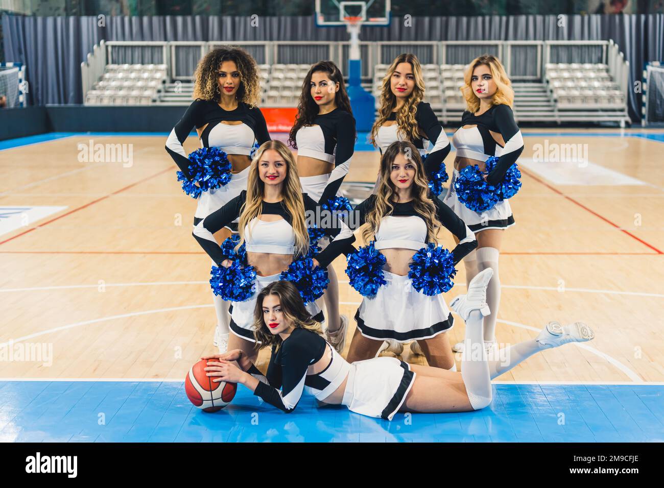 Full shot of a cheerleading squad posing for a picture in three rows ...