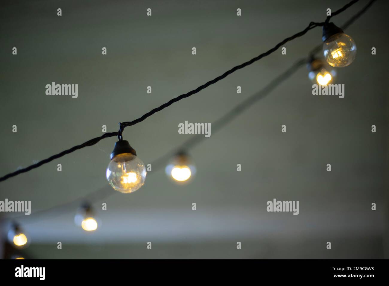 Light bulbs on wires. Garlands in interior. Incandescent lamp Stock ...