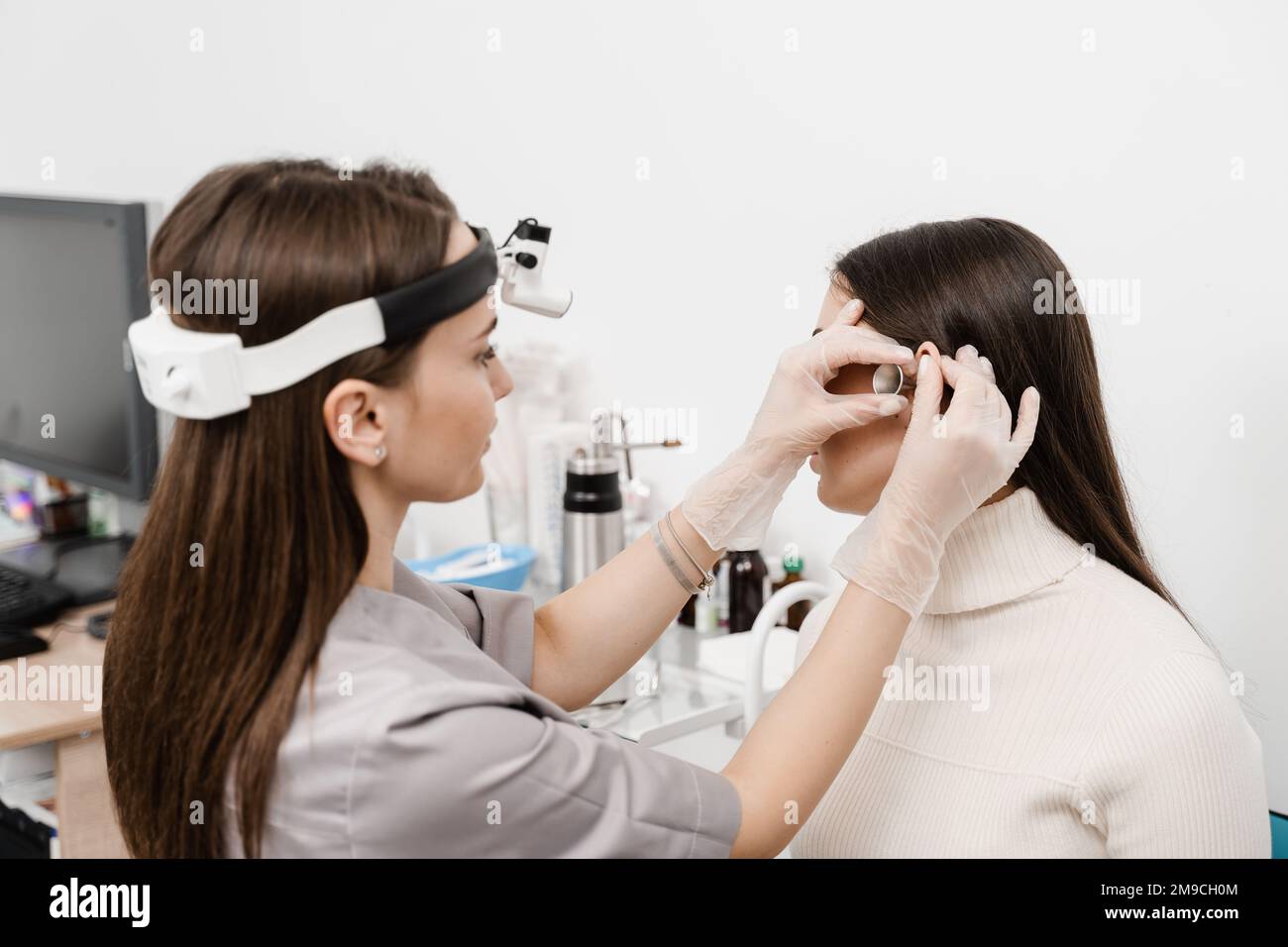 ENT doctor with ear funnel. Otoscopy. Otolaryngologist is looking ...