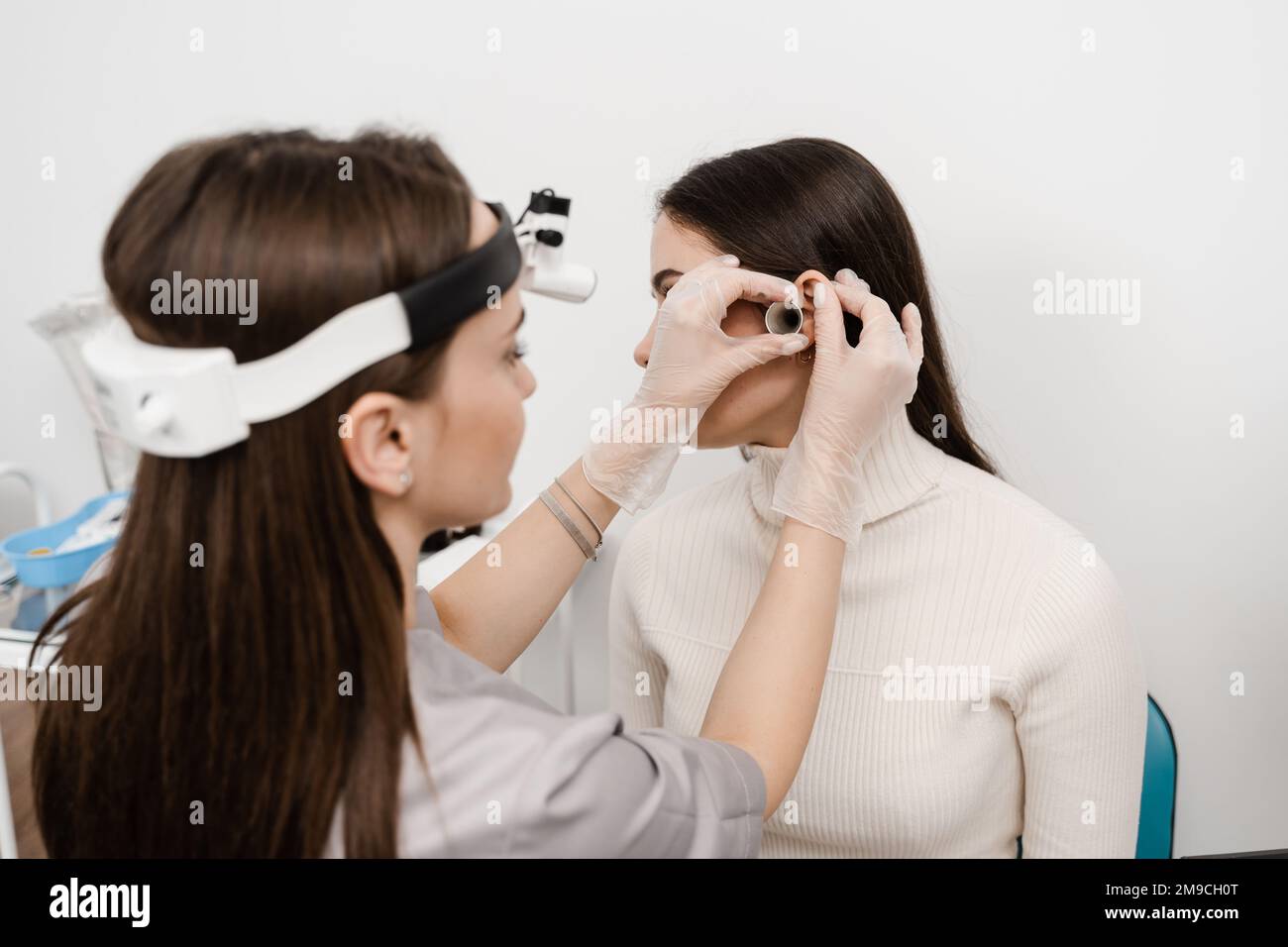 Otoscopy. Otolaryngologist is looking through otoscope the ears of ...