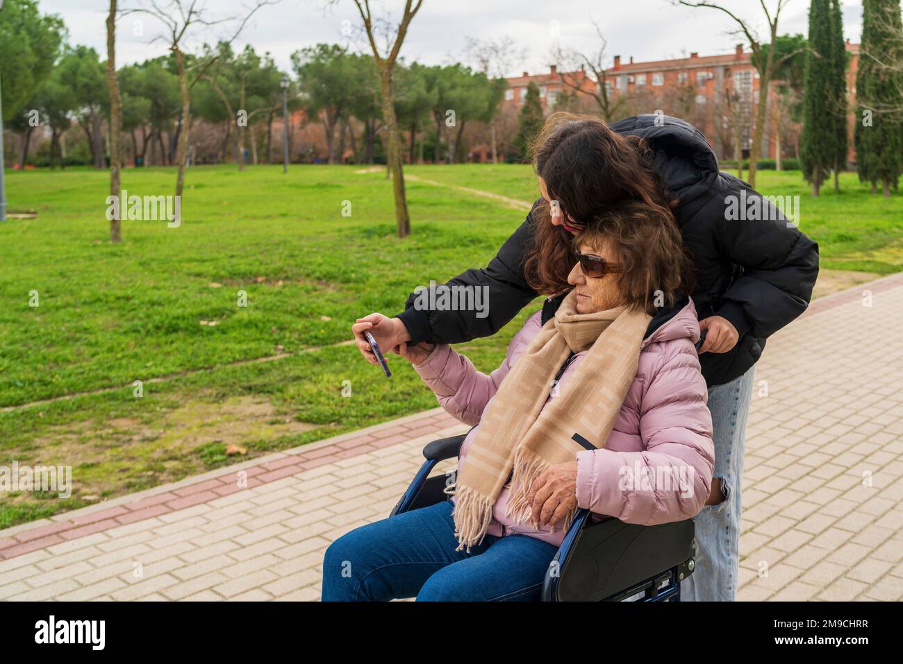 a girl taking photos with her grandmother in a wheelchair Stock Photo ...