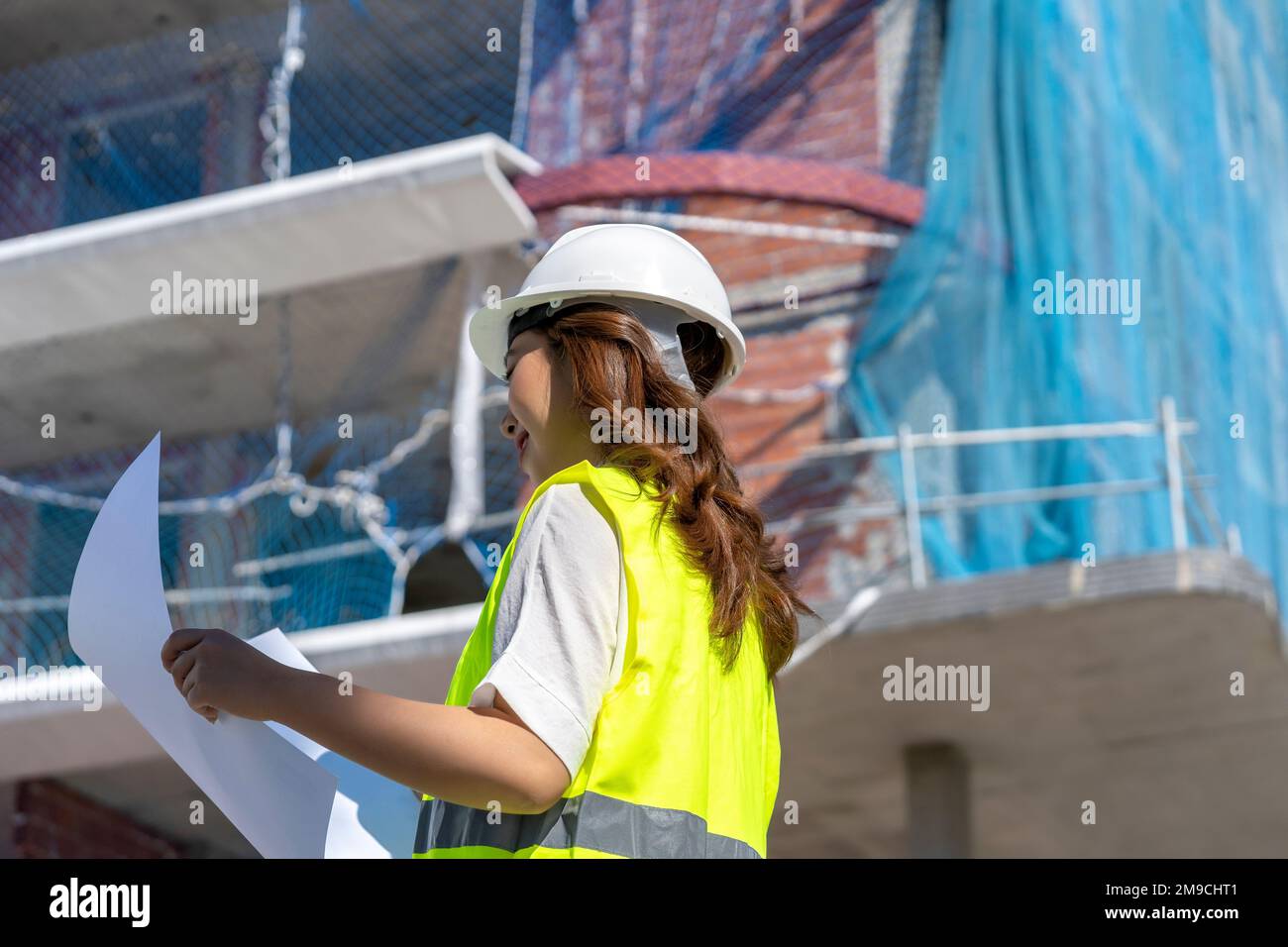 female architect checking construction plans Stock Photo - Alamy