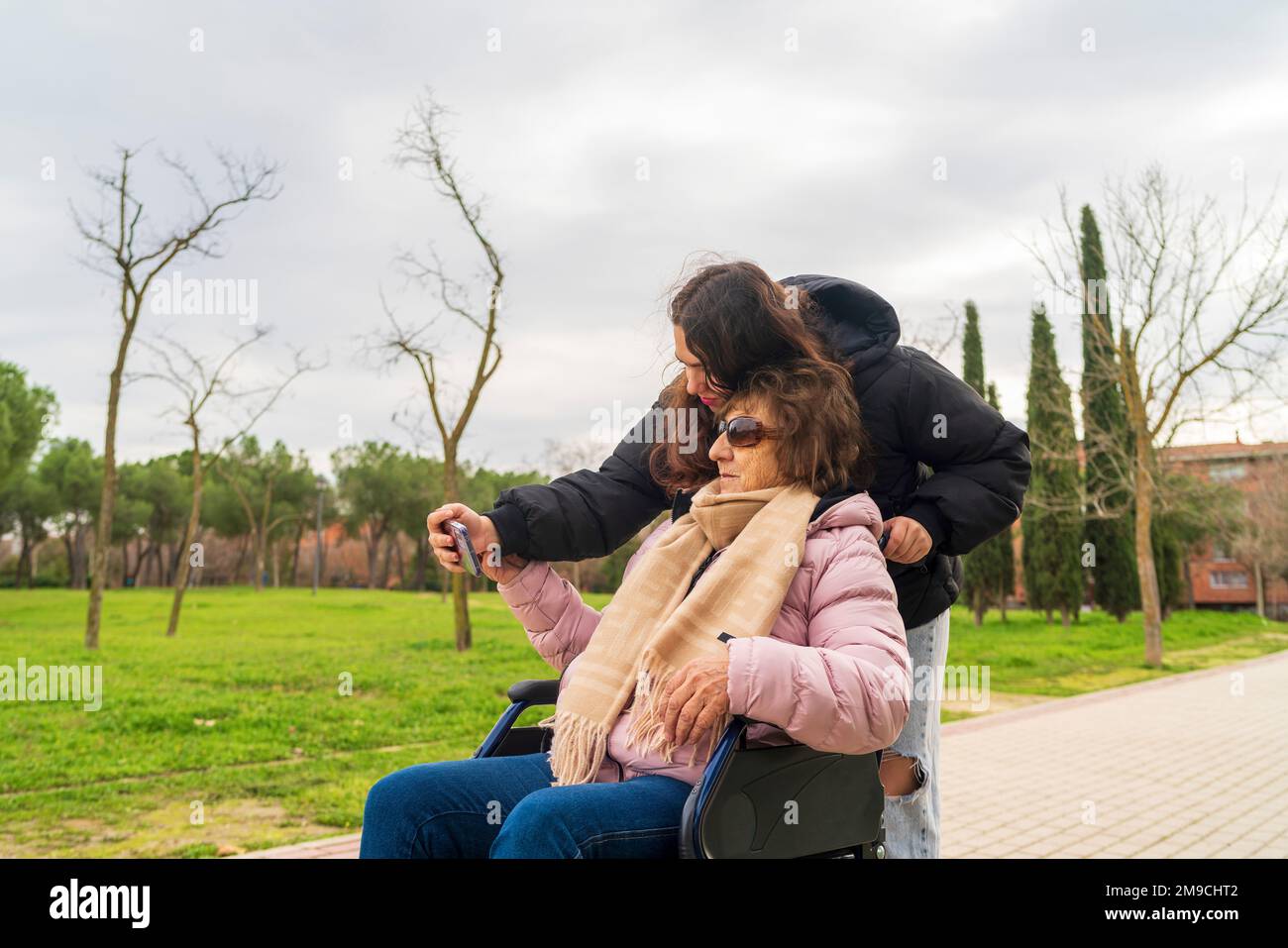 a girl taking photos with her grandmother in a wheelchair Stock Photo ...