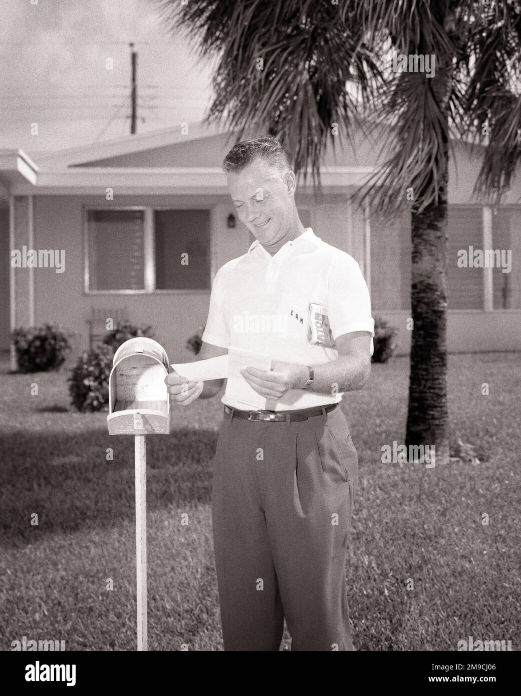 1950s SENIOR RETIRED MAN TAKING MAIL FROM MAILBOX IN FRONT OF HIS ...