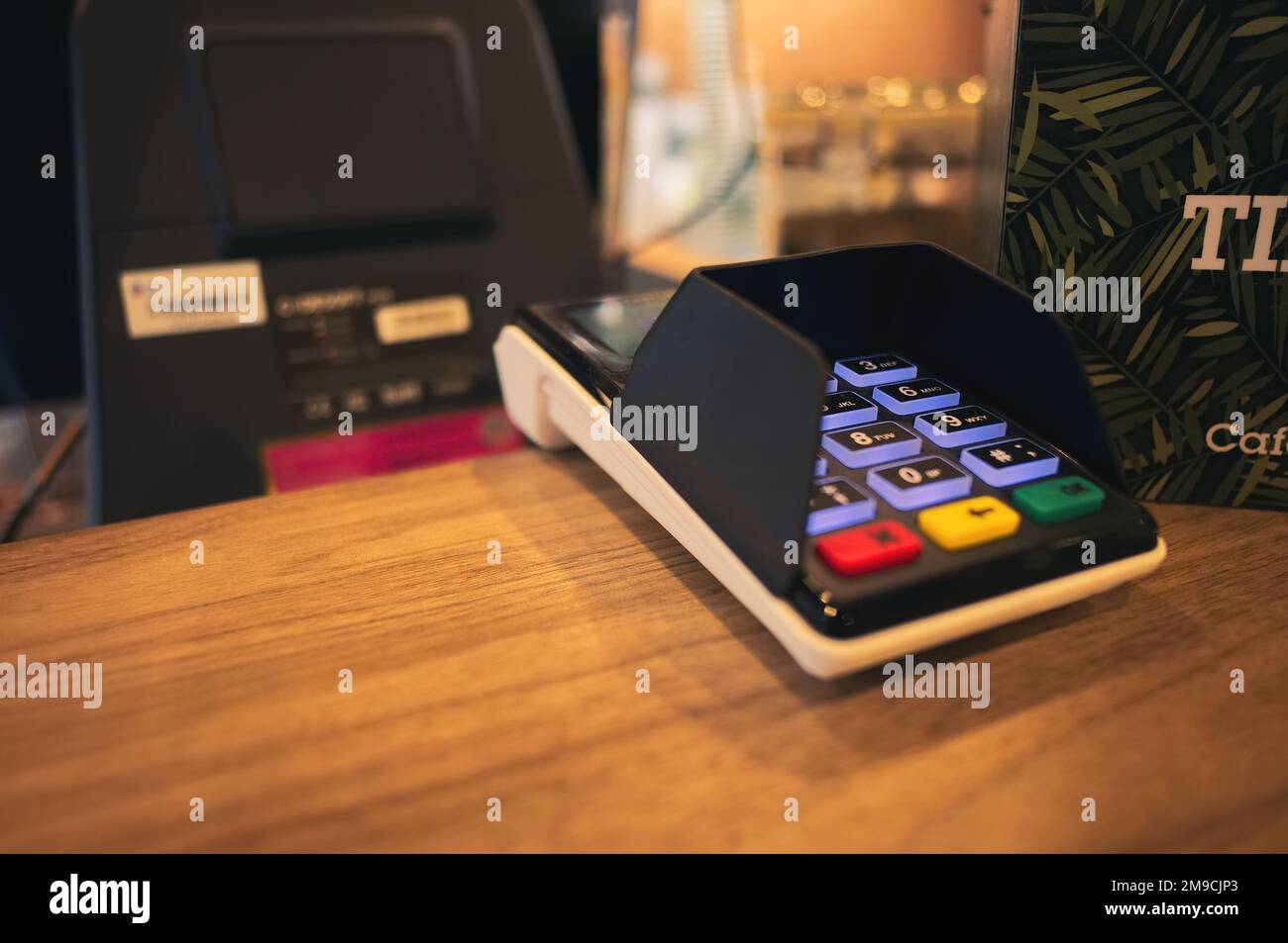 Paying with device in coffee shop counter bar Stock Photo - Alamy