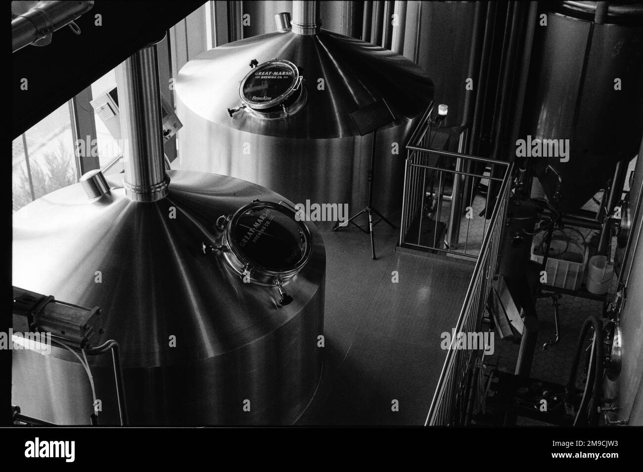 The interior of a brew pub with two metal fermentation tanks visible in ...