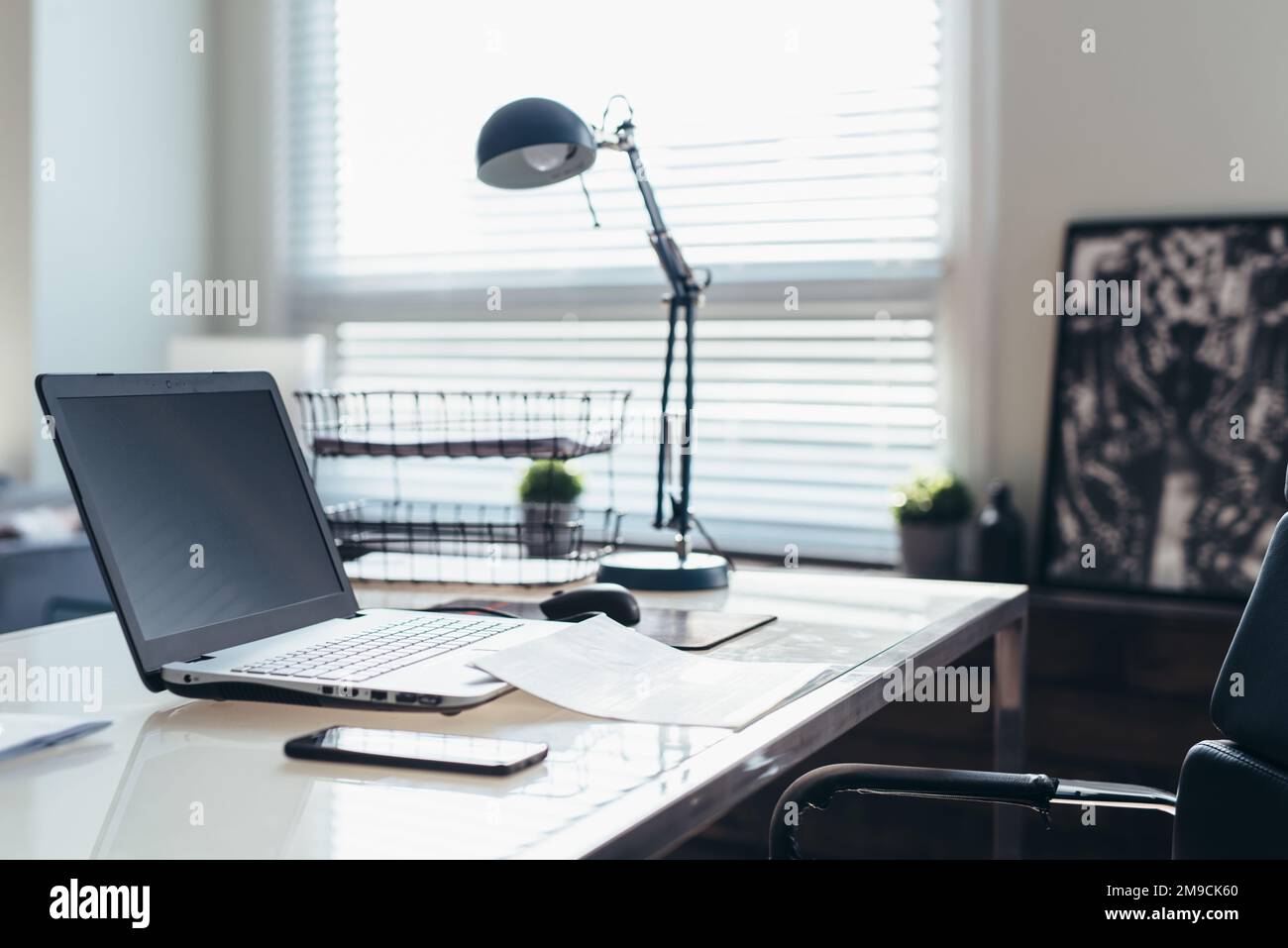 Office workplace with laptop on table against the windows Stock Photo ...