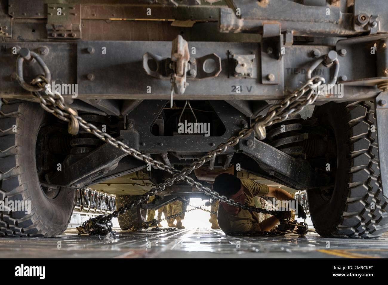 U.S. Airmen secure a High Multipurpose Mobility Wheeled Vehicle on a C ...