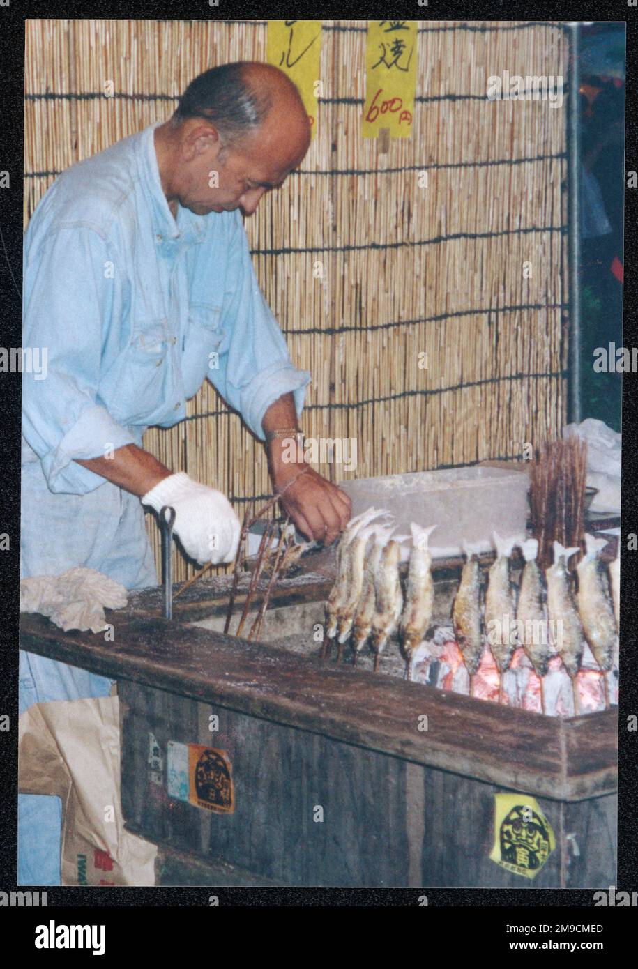 A Japanese man cooking fish during the summer 'hanabi' (fireworks ...