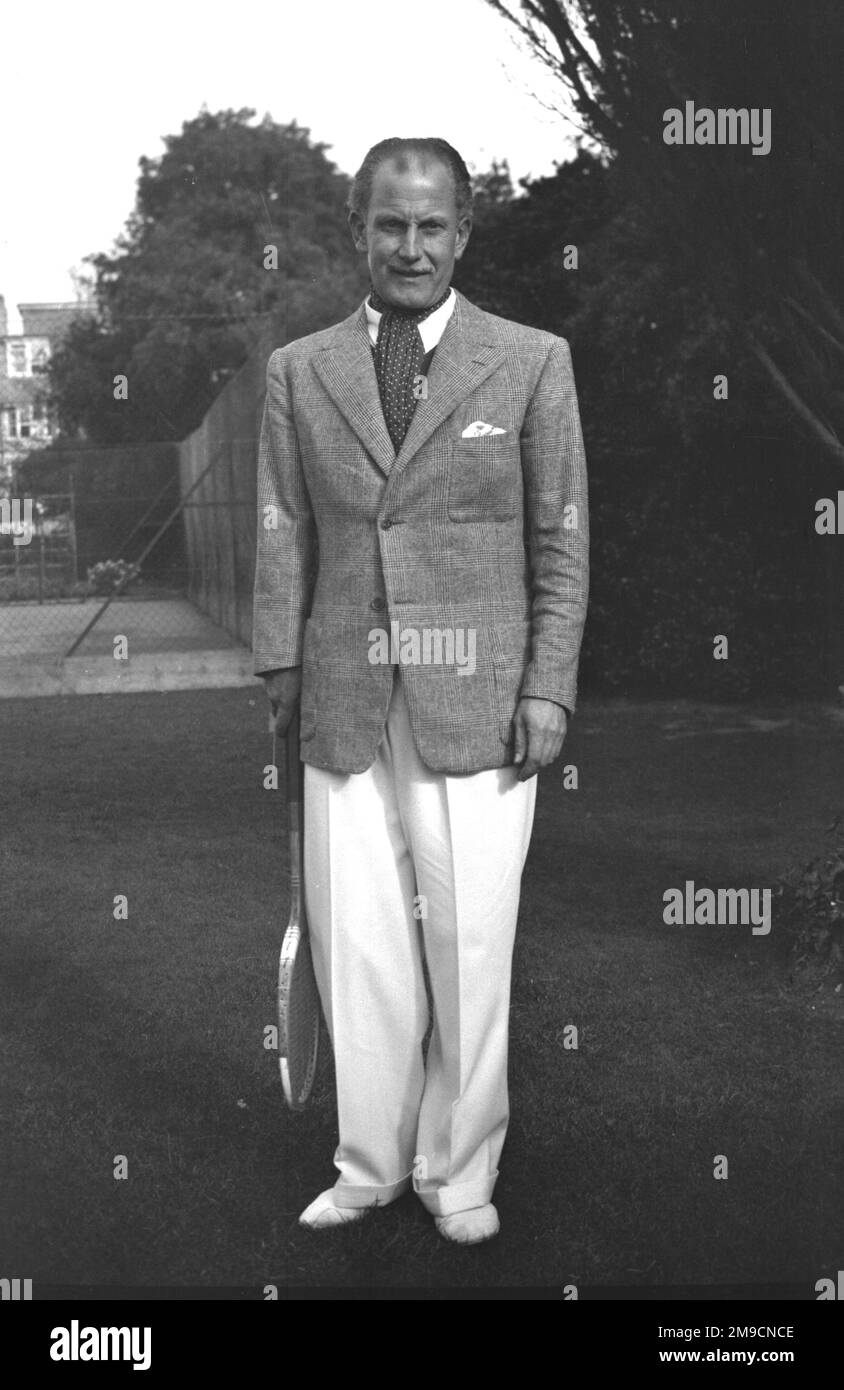 A smart gentleman with a tennis racket Stock Photo - Alamy