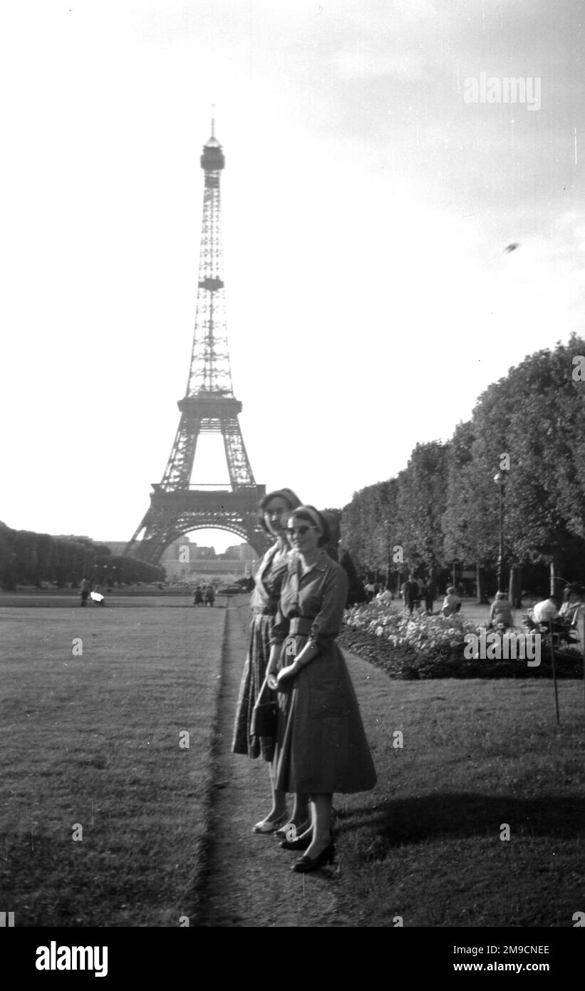 Two women sightsee in Paris, standing near the Eiffel Tower Stock Photo ...