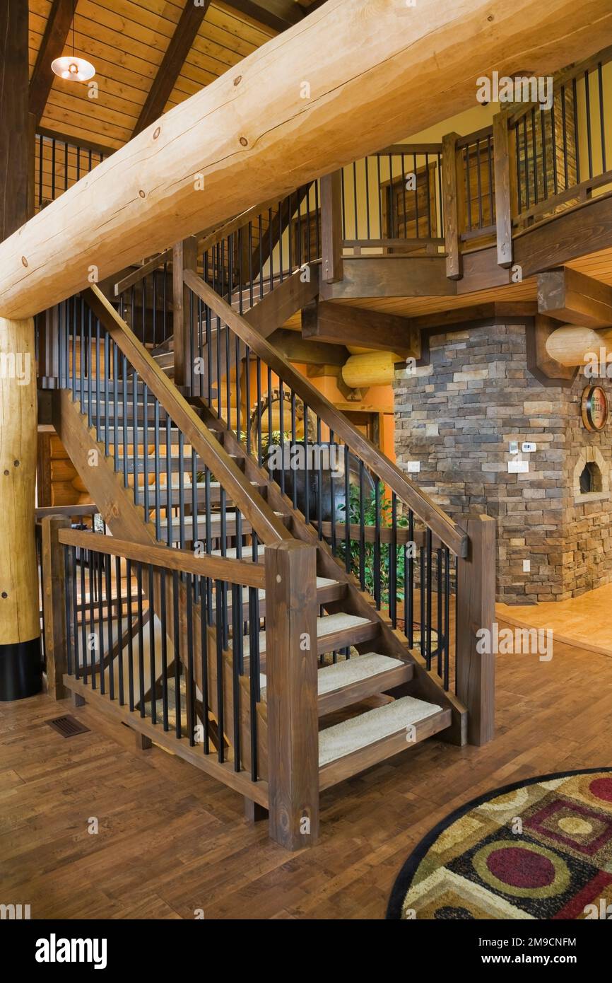Overhead wooden log beam and brown stained pine wood staircase and ...