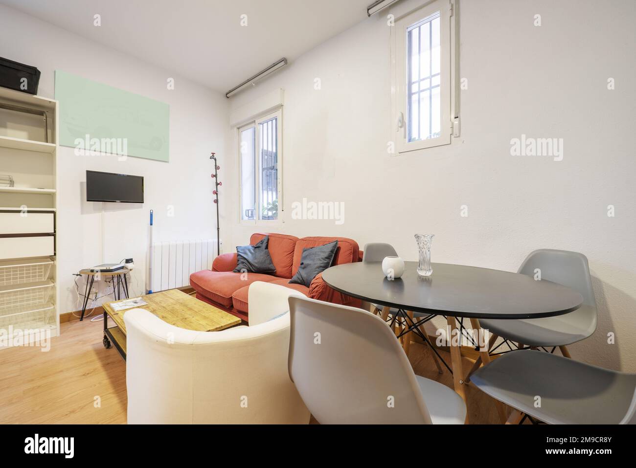 Loft apartment with round black dining table and gray resin chairs with ...