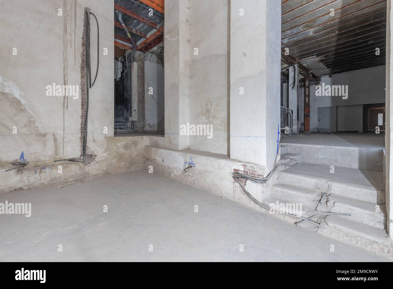 Raw underground premises with cement floors and grooves for pipes and ...