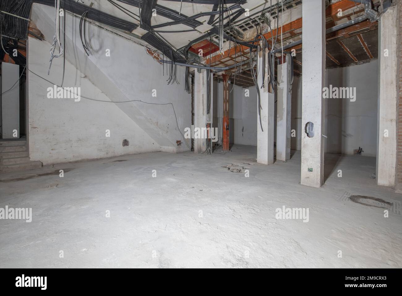 Raw underground premises with cement floors and grooves for pipes and ...