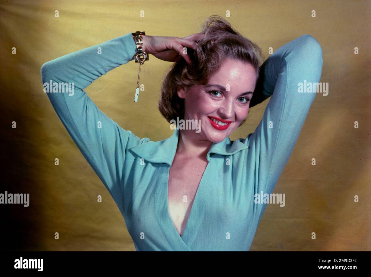 Female model in a pale blue top with her arms raised Stock Photo - Alamy