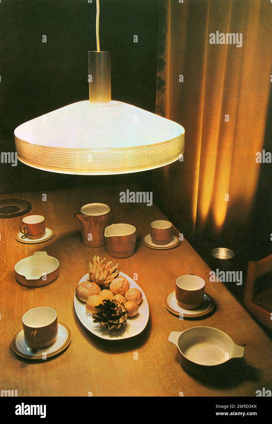 Advertisement for Rotaflex lighting, with low-hanging lamp and table ...