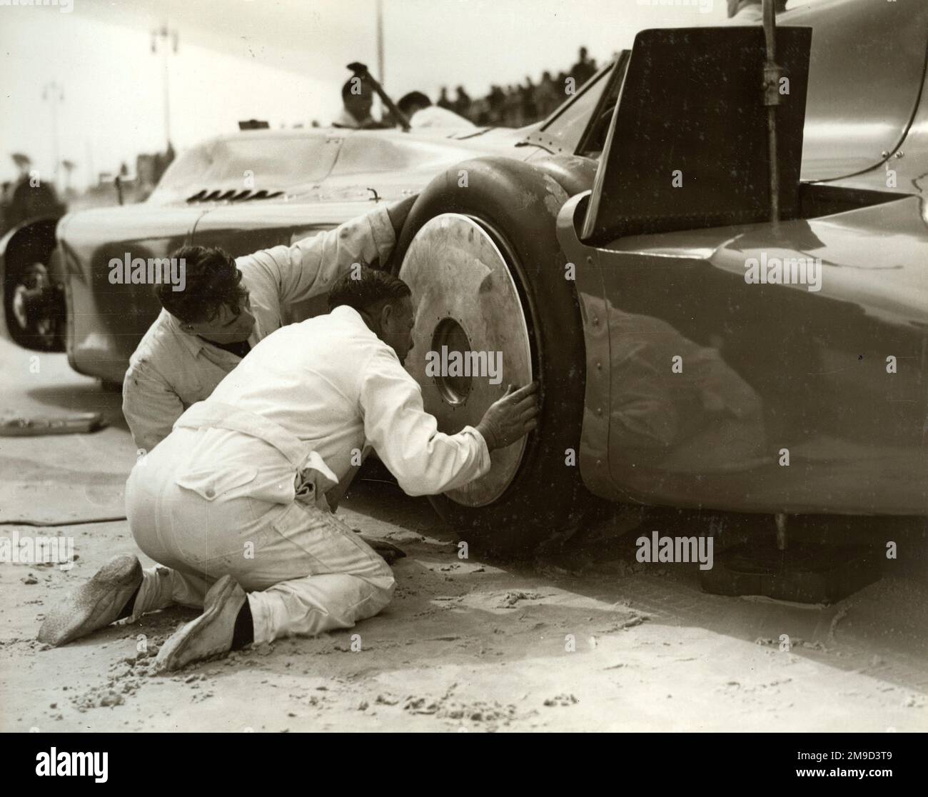 Close-up view of mechanics fitting hubcaps to Blue Bird rear nearside ...