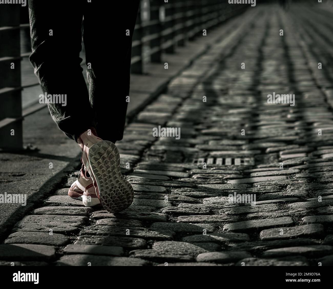 A person wearing rubber shoes on an old stone pavement pathway Stock ...