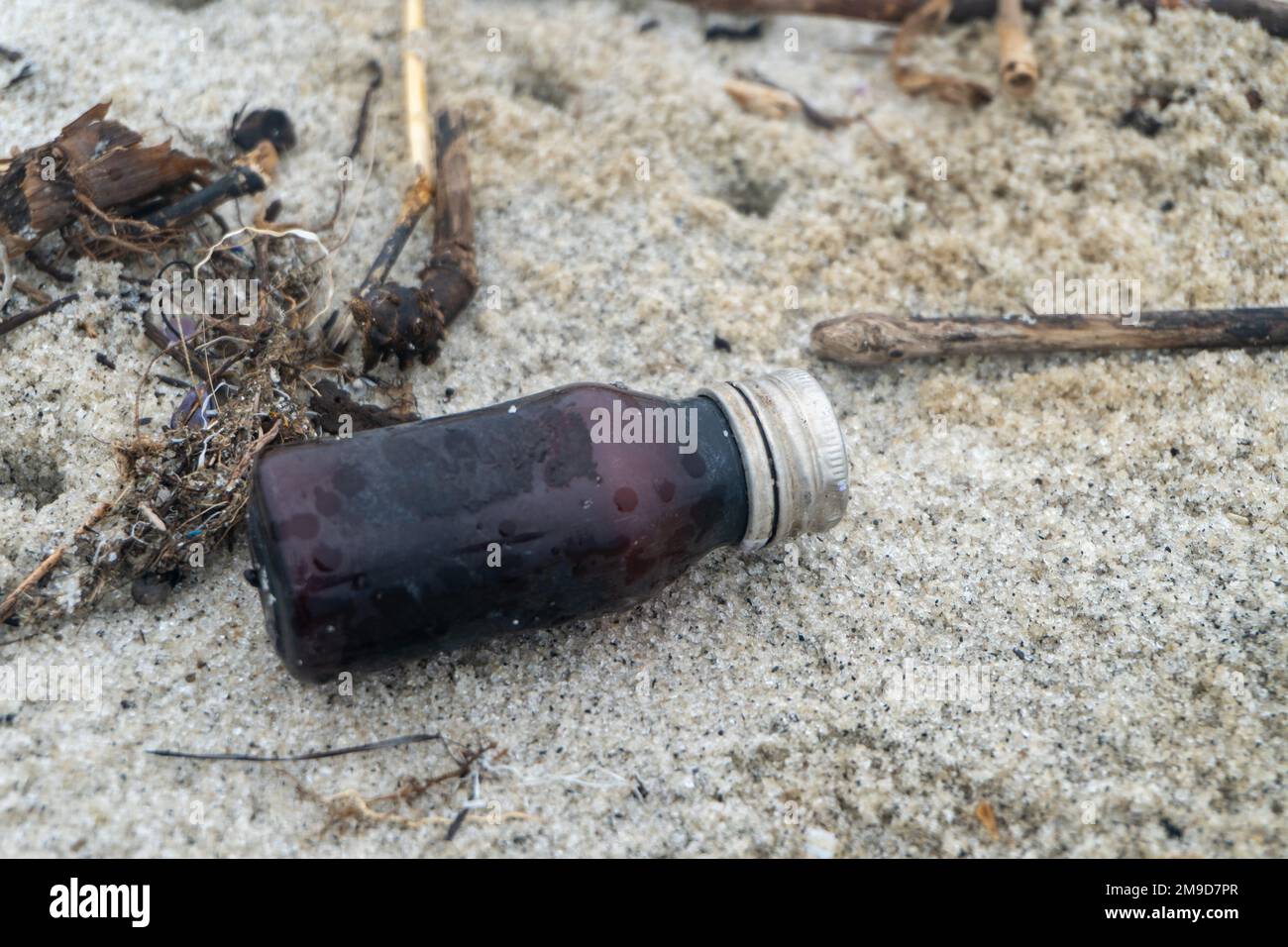 glass bottle trash on the seafront white sandy beach in the middle of ...