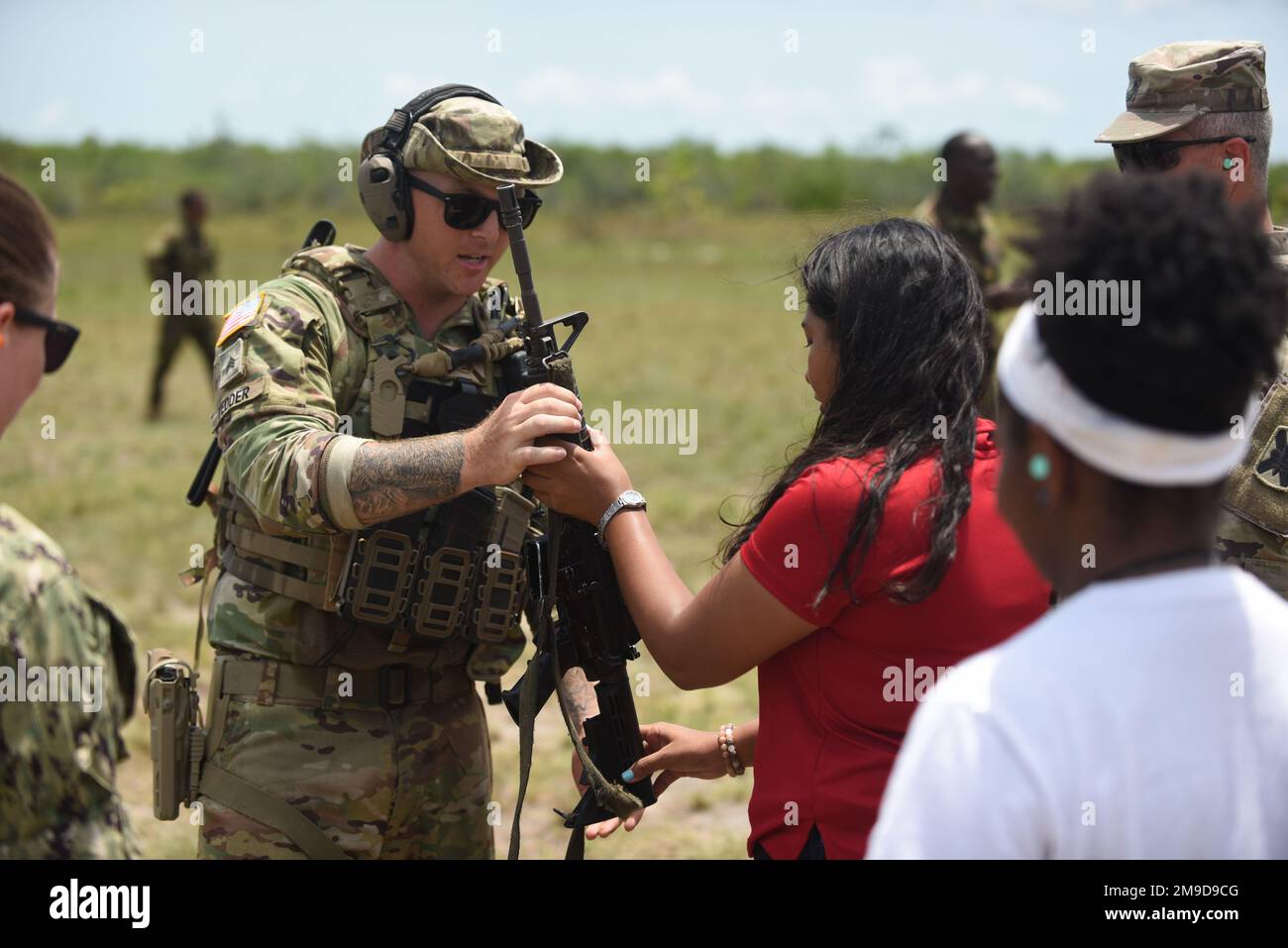 U.S. Army Sgt. Blake Tedder, Florida Army National Guard, hands an M4 ...