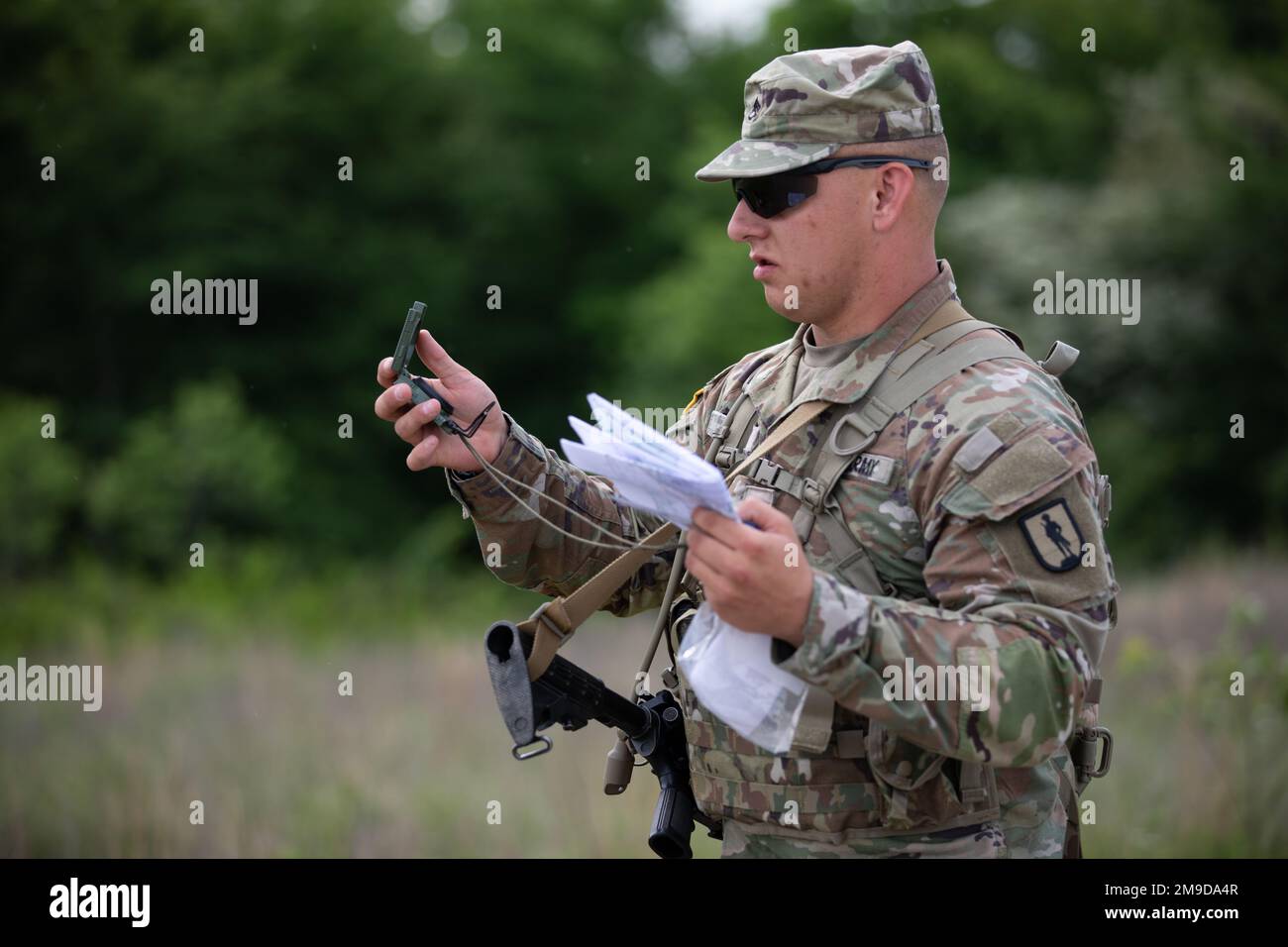 An Army National Guard Soldier uses his compass during the land ...