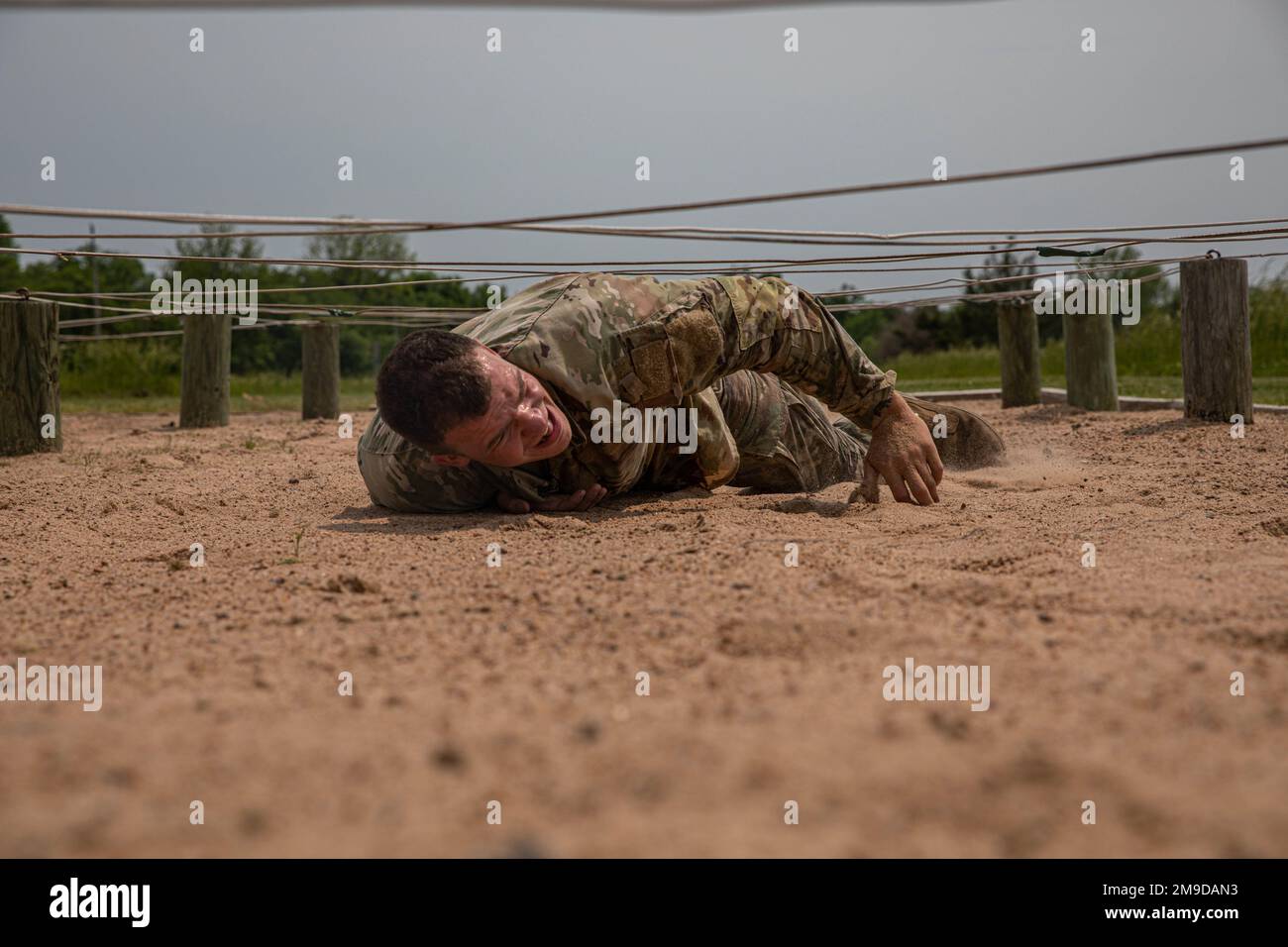 Spc. Keyes Nelson, Nebraska National Guard, crawls through an obstacle ...