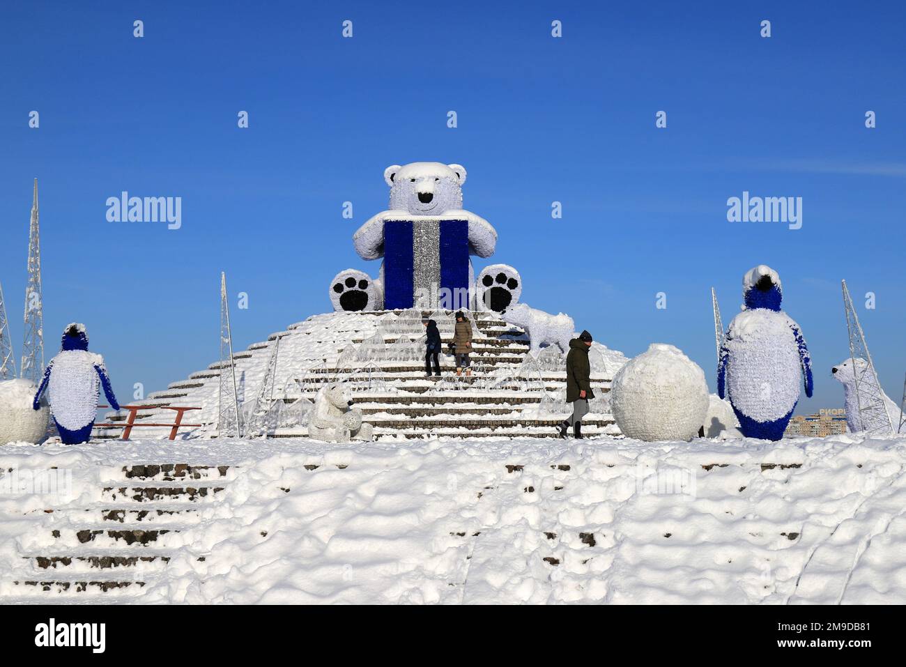 Large polar bear stands on city street in winter, festive toy. People ...