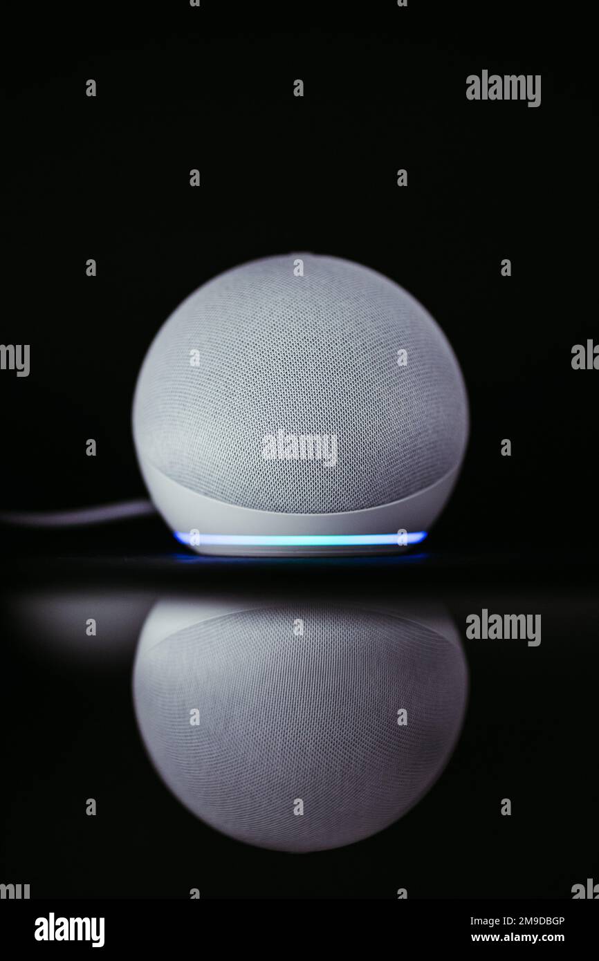 A vertical shot of Amazon Echo 4 with neon blue led light on the bottom ...