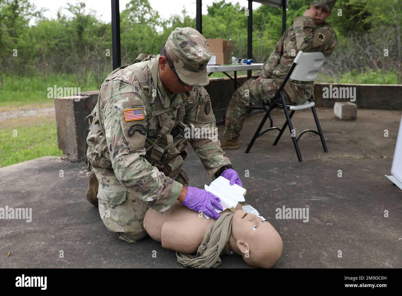 An Army National Guard competitor bandages a simulated gunshot wound on ...