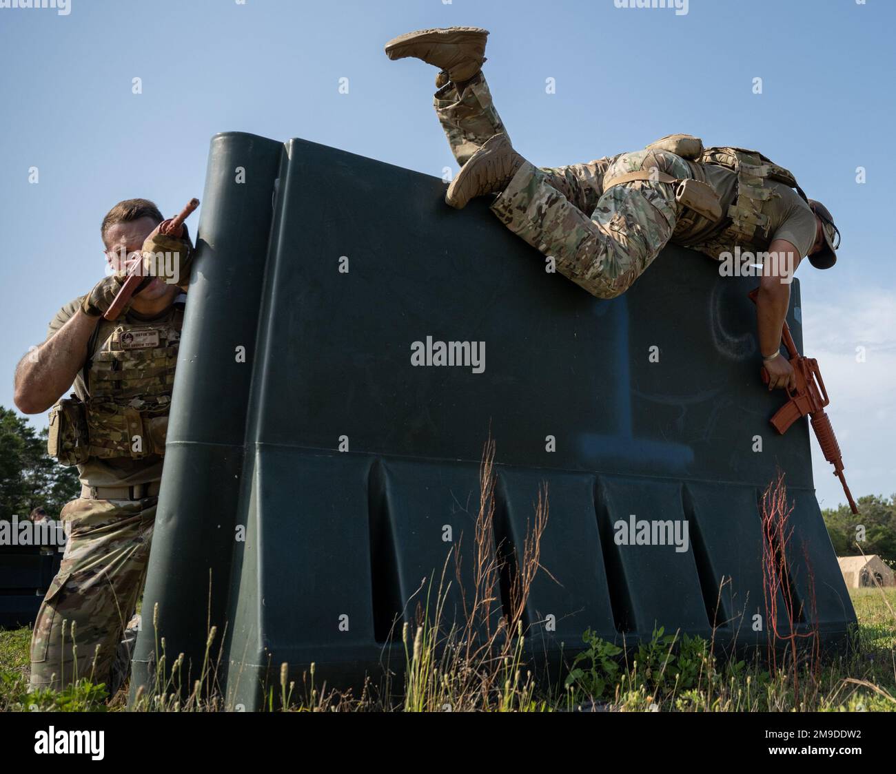 An Airman bounds over a barrier during part of the Defender Challenge ...