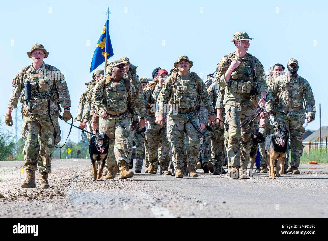 Members of the 460th Security Forces Squadron march down a road in ...