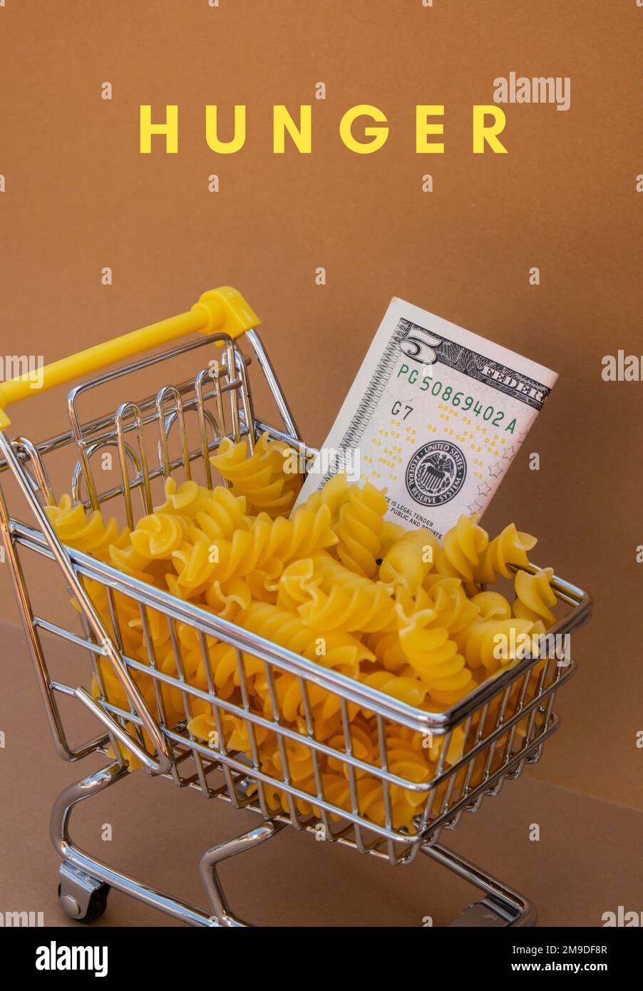 HUNGER text against Shopping trolley cart Filled With Pasta with 5 US ...