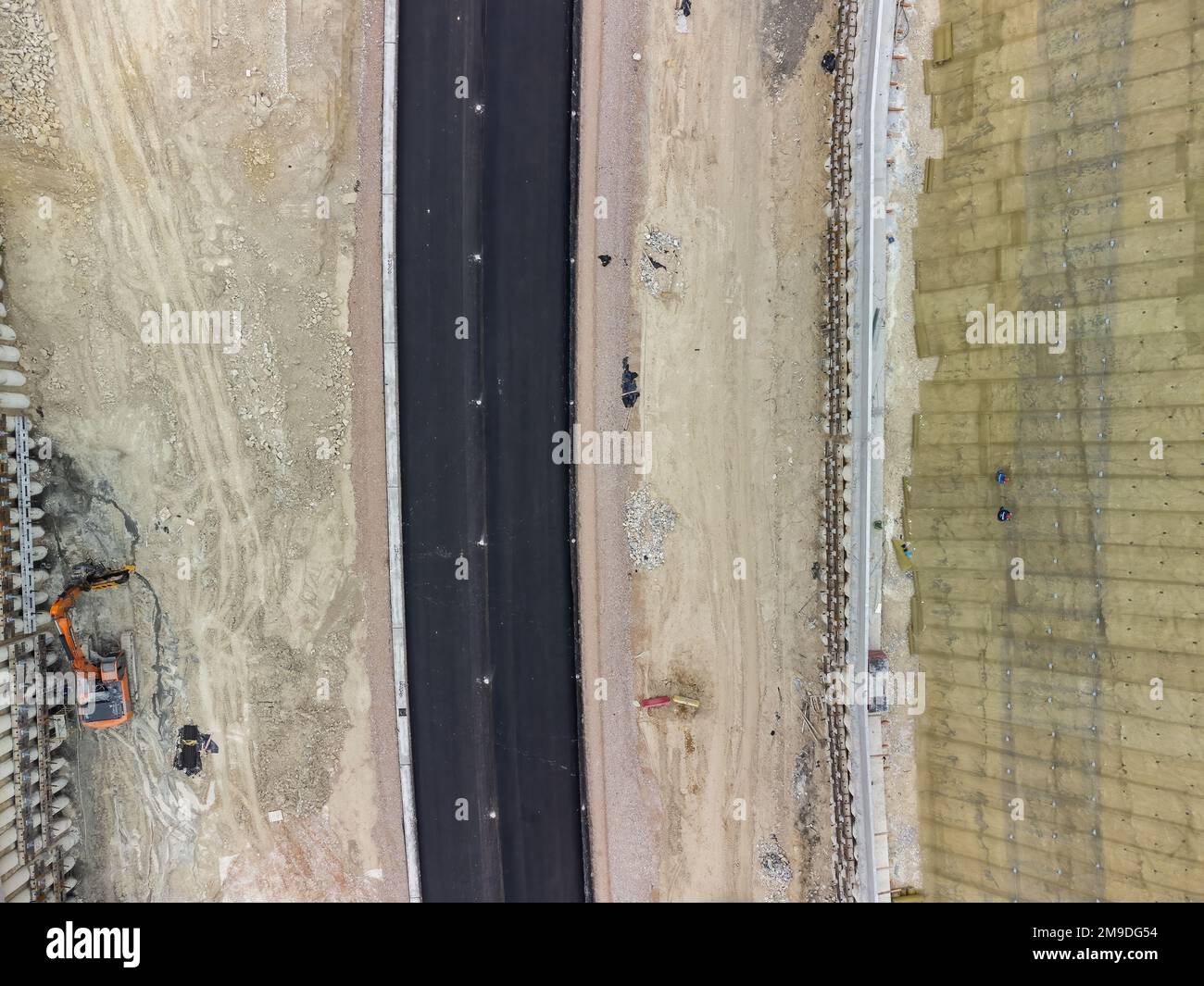 Mountain road constraction. Workers reinforce the slope over the new ...