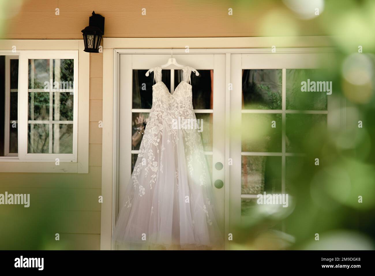 White lace wedding dress hanging on the dookr outside the house in the ...