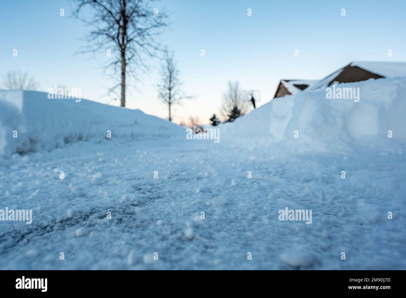 Selective focus ground level view of snow blown sidewalk section with ...