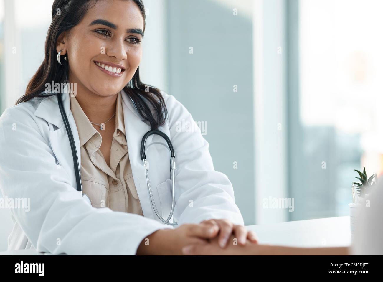 Youre in good hands, I promise. an attractive young doctor sitting and ...