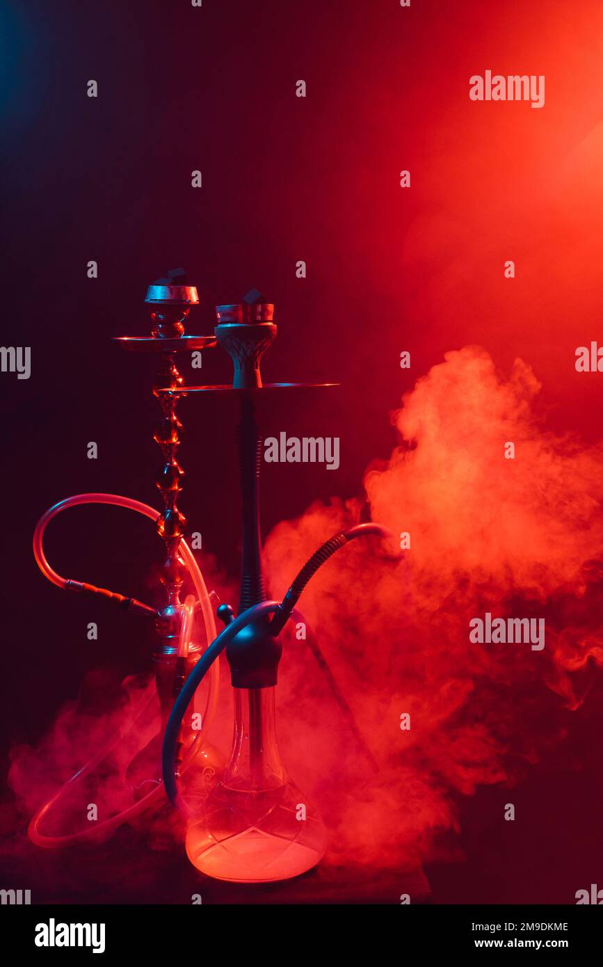 modern hookah, shisha on smoky black background with colored lighting ...
