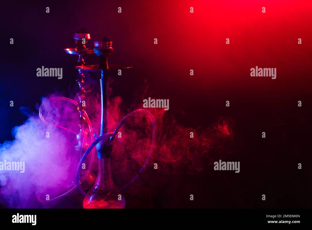 Modern hookah, shisha on smoky black background with colored lighting ...