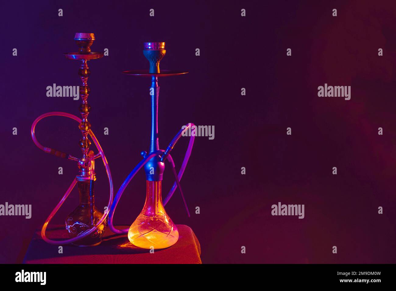 Modern hookah, shisha on black background with colored lighting and ...